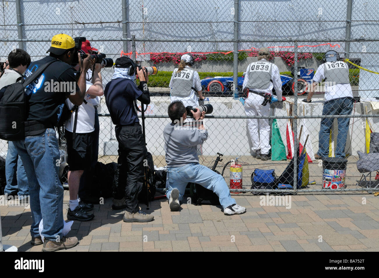 Photographers trying to get a good shot of the fast race cars Stock ...