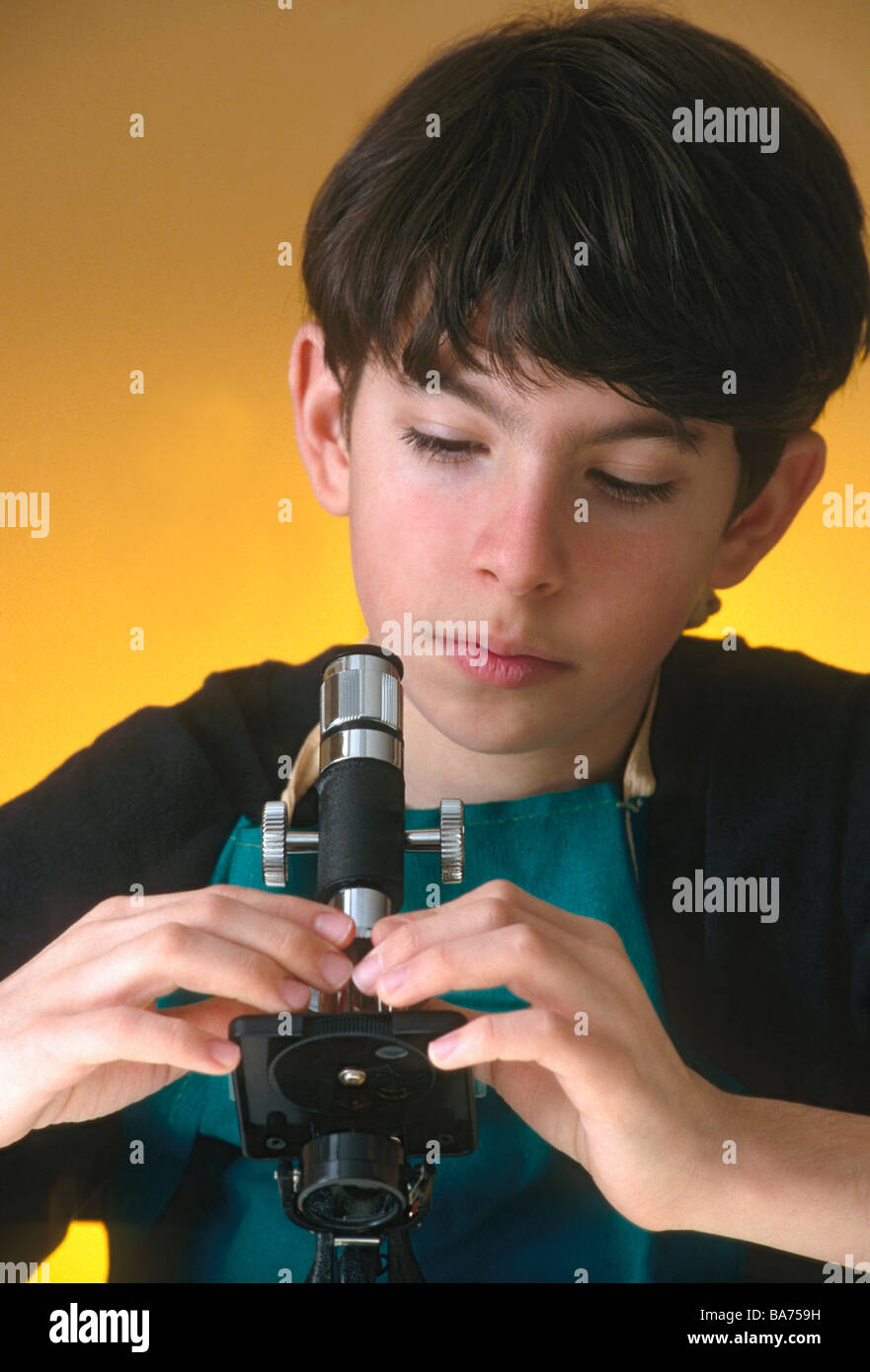 Caucasian teenage boy science student working with microscope in ...