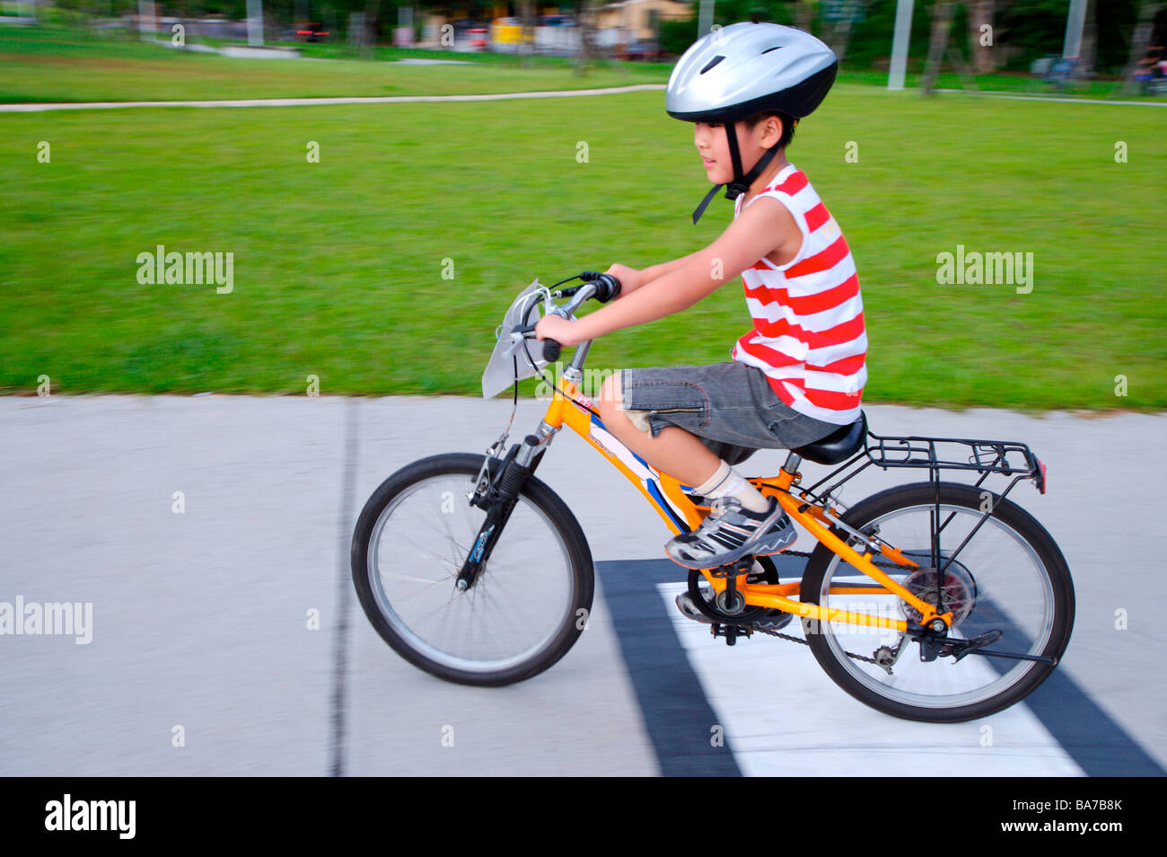 Boy riding bicycle on road Stock Photo - Alamy