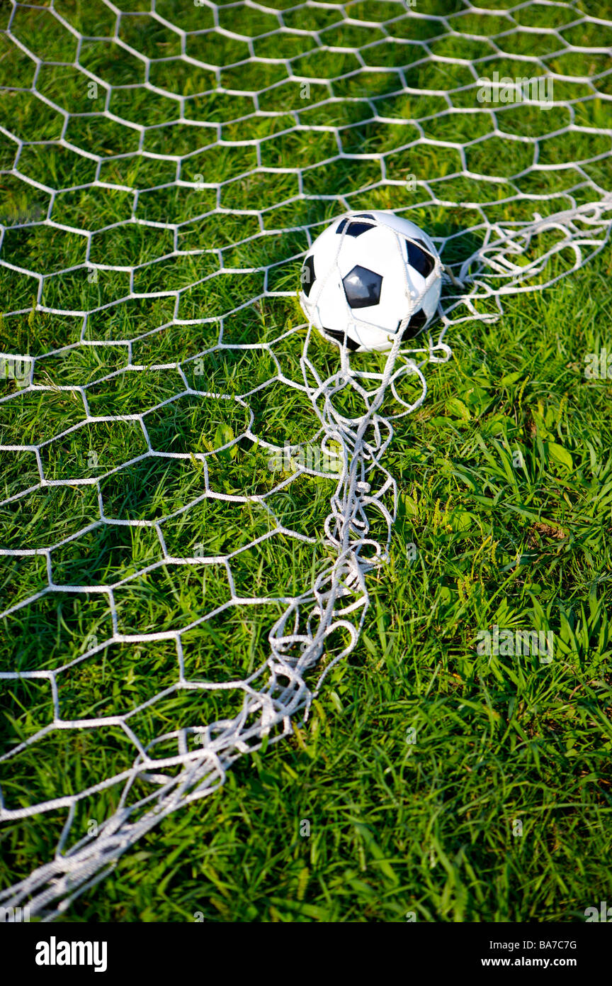 Football resting on goal net close up Stock Photo - Alamy