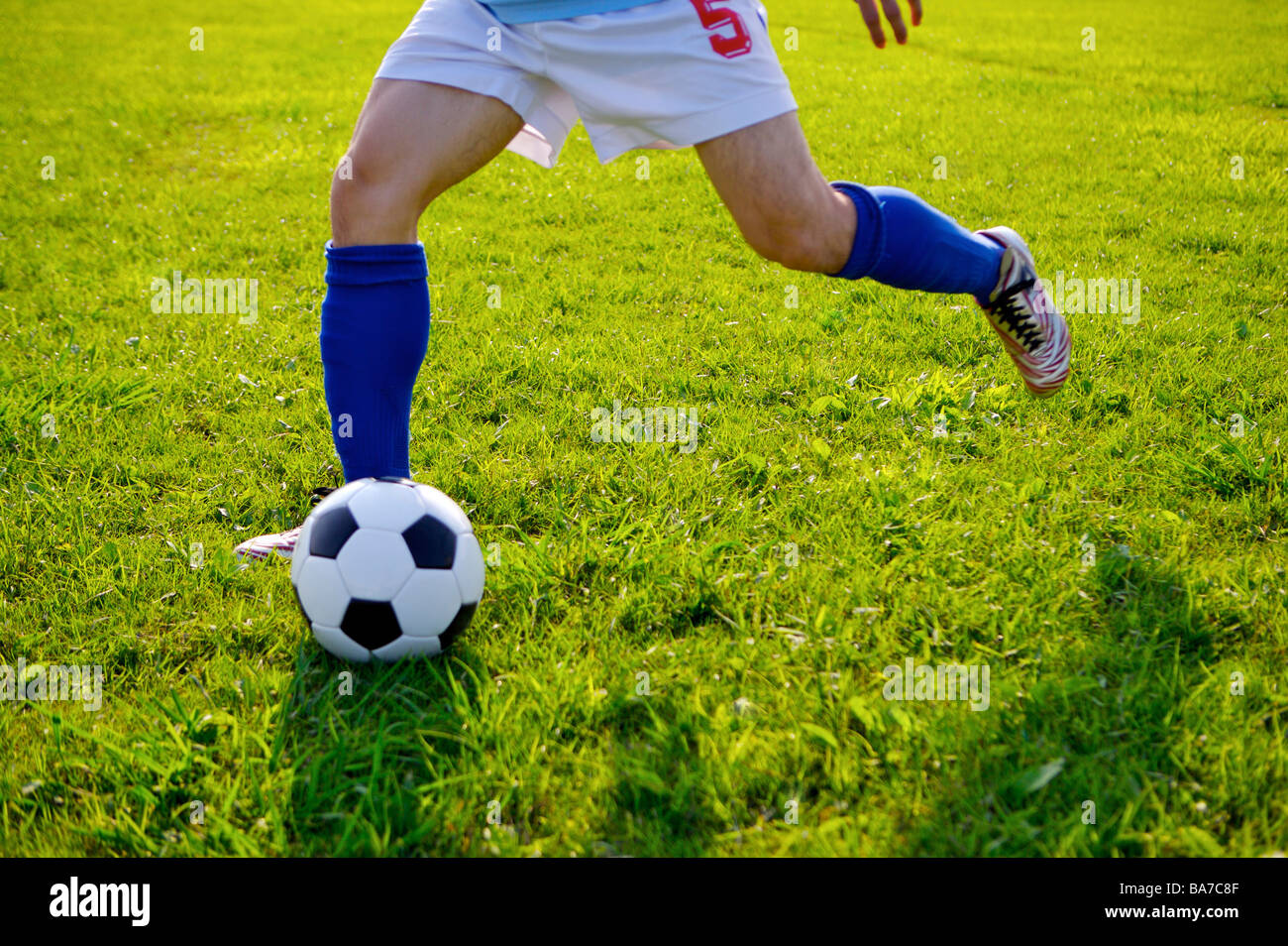 Soccer player kicking ball mid section Stock Photo - Alamy