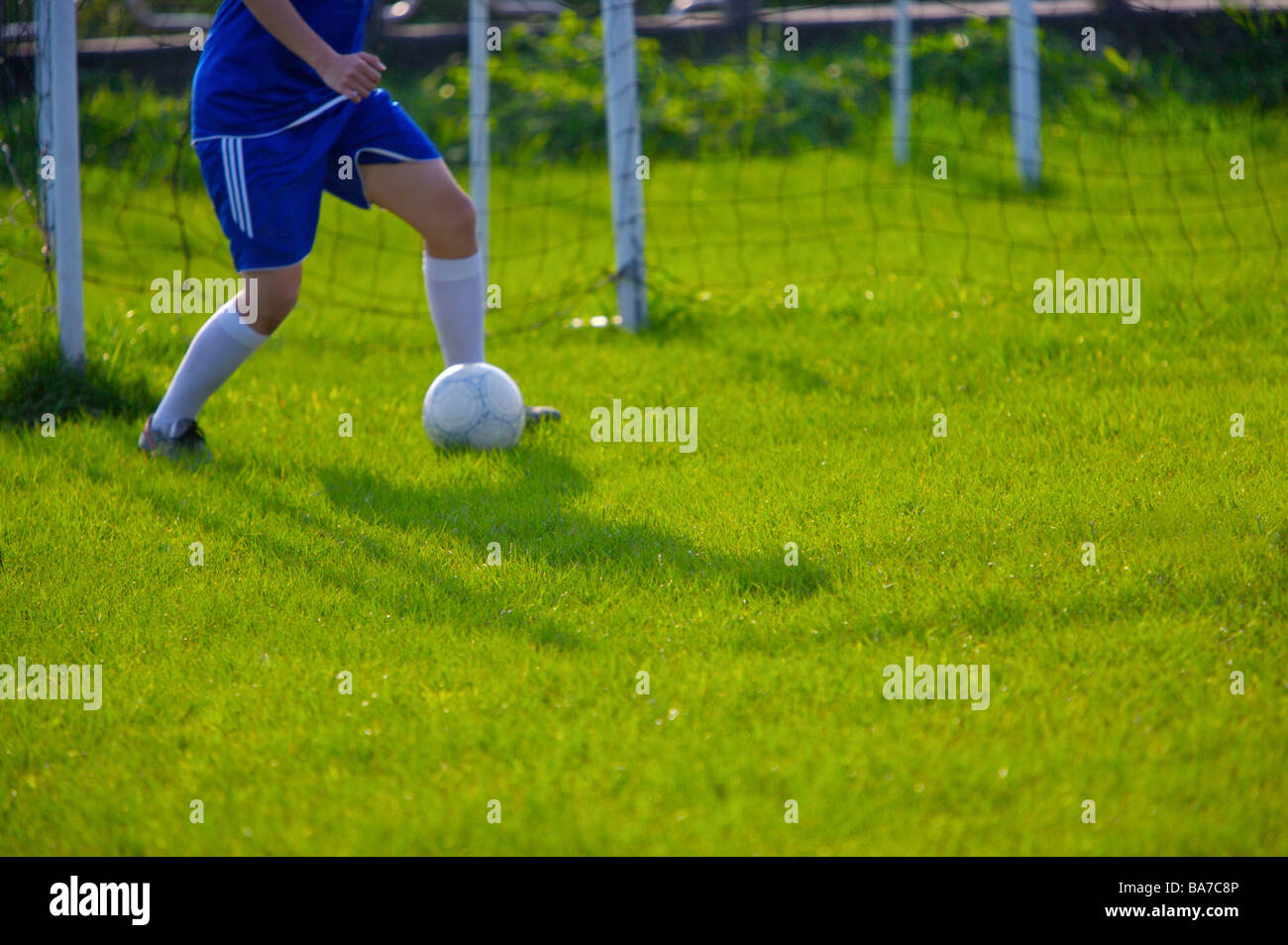 Soccer player kicking ball mid section Stock Photo - Alamy