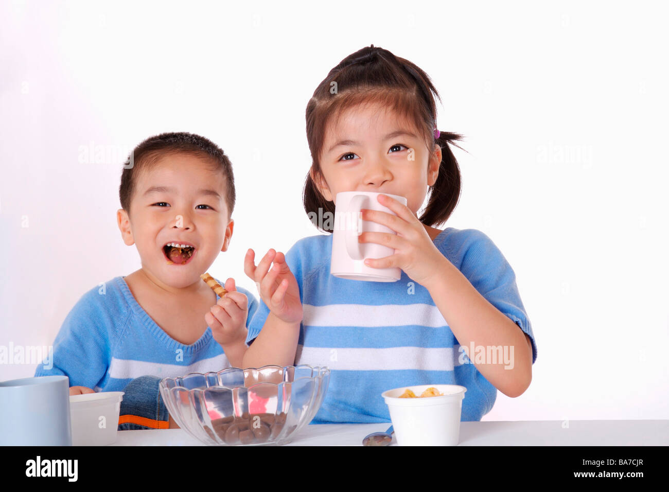 Children eating breakfast smiling portrait Stock Photo - Alamy