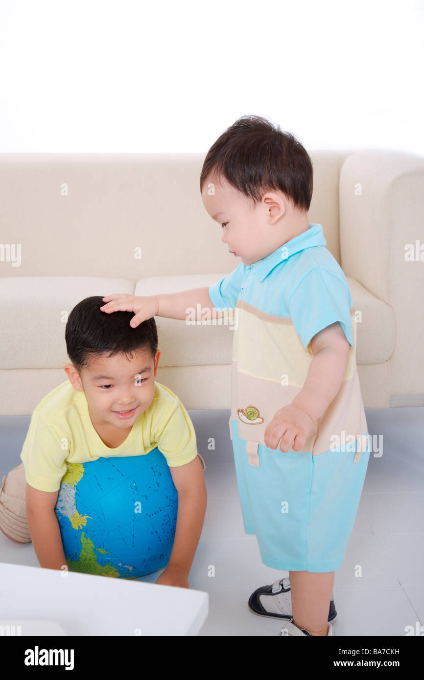 Baby boy touching boy s head Stock Photo - Alamy