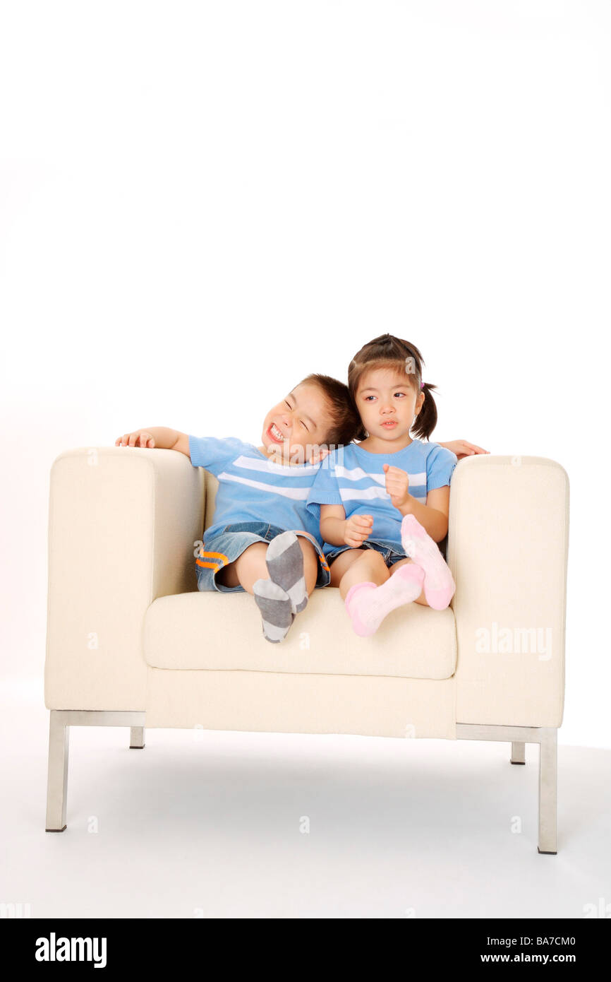 Two children sitting on sofa Stock Photo - Alamy