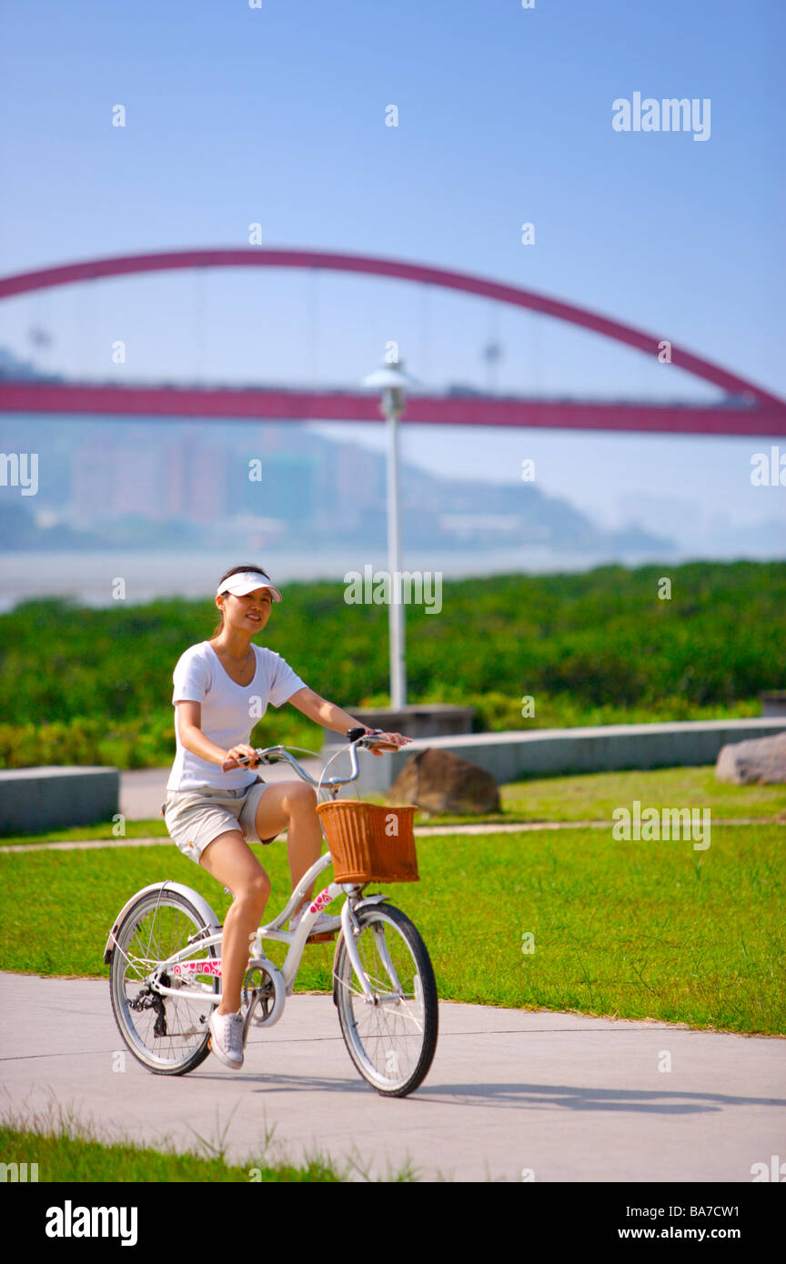 Young woman riding bicycle on road Stock Photo - Alamy