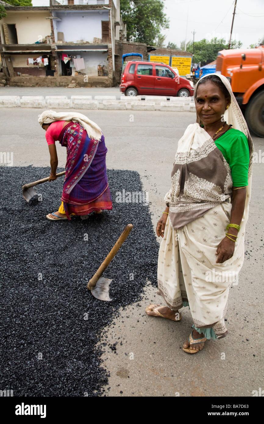 Woman labourers / road workers spreading asphalt on a road in Surat ...