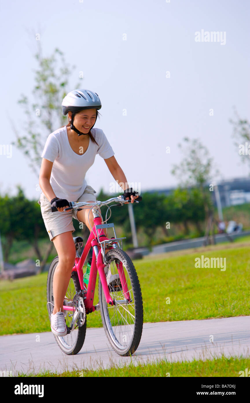 Young woman riding bicycle on road Stock Photo - Alamy
