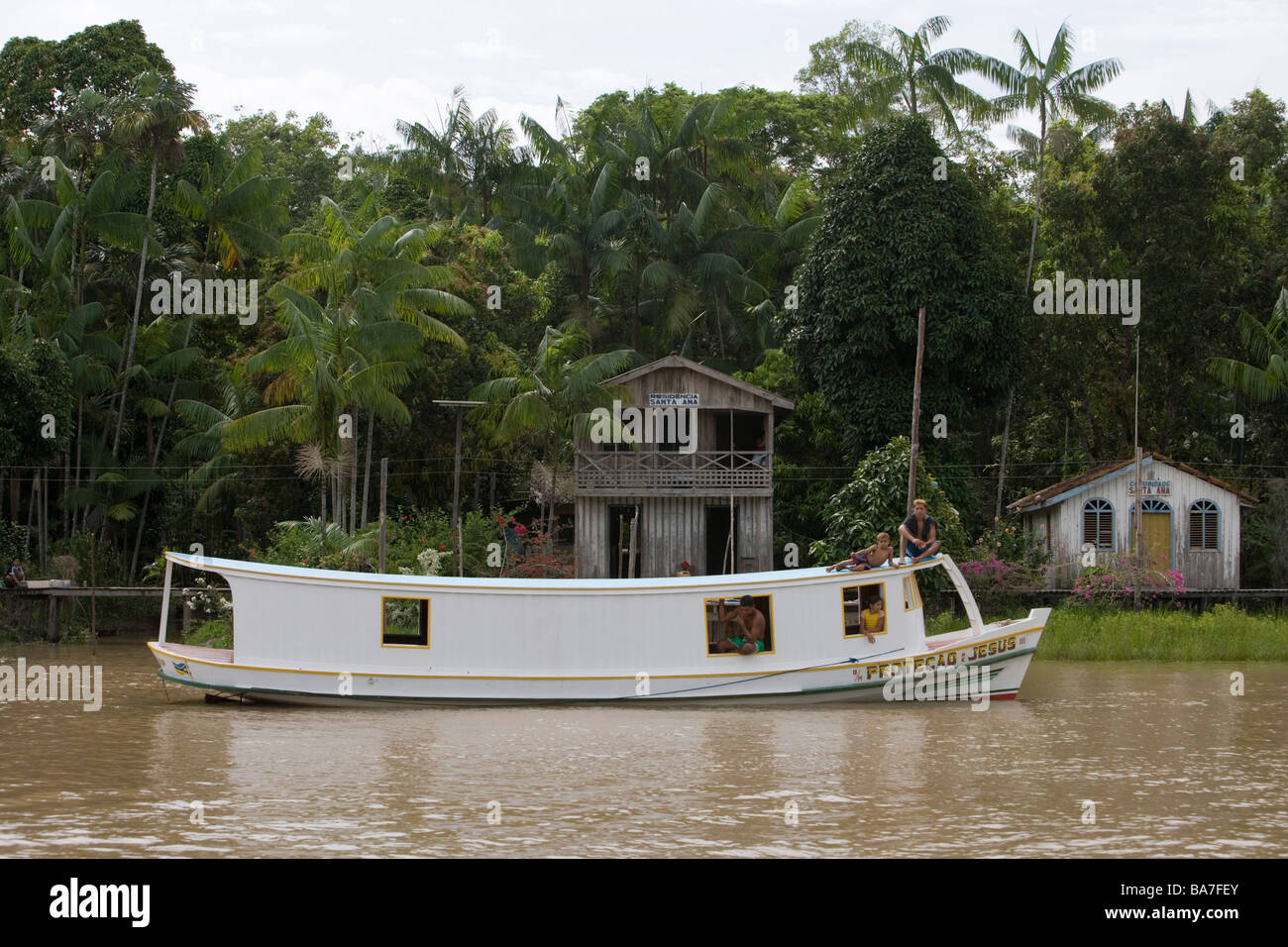 Boat and houses along the riverbank on a branch of the Amazon River ...
