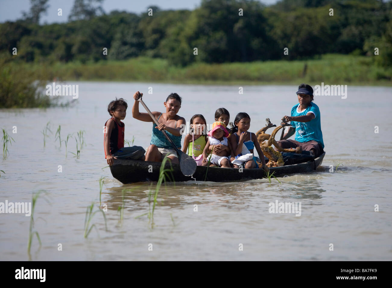 Amazon Indian family in a canoe on a sidearm of the Amazon River, Boca ...