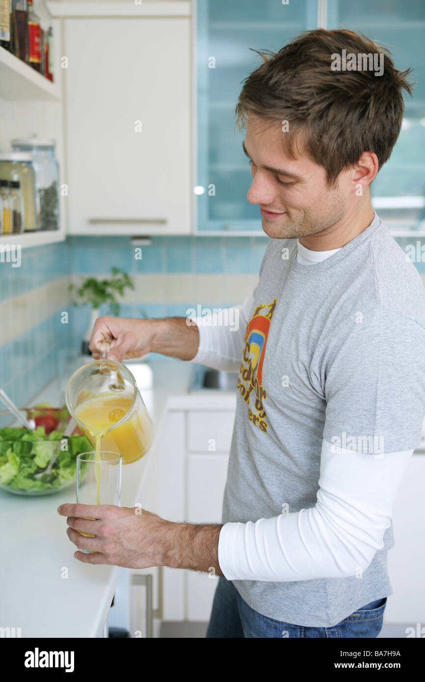 Young man pouring a glass of orange juice, Munich, Germany Stock Photo ...
