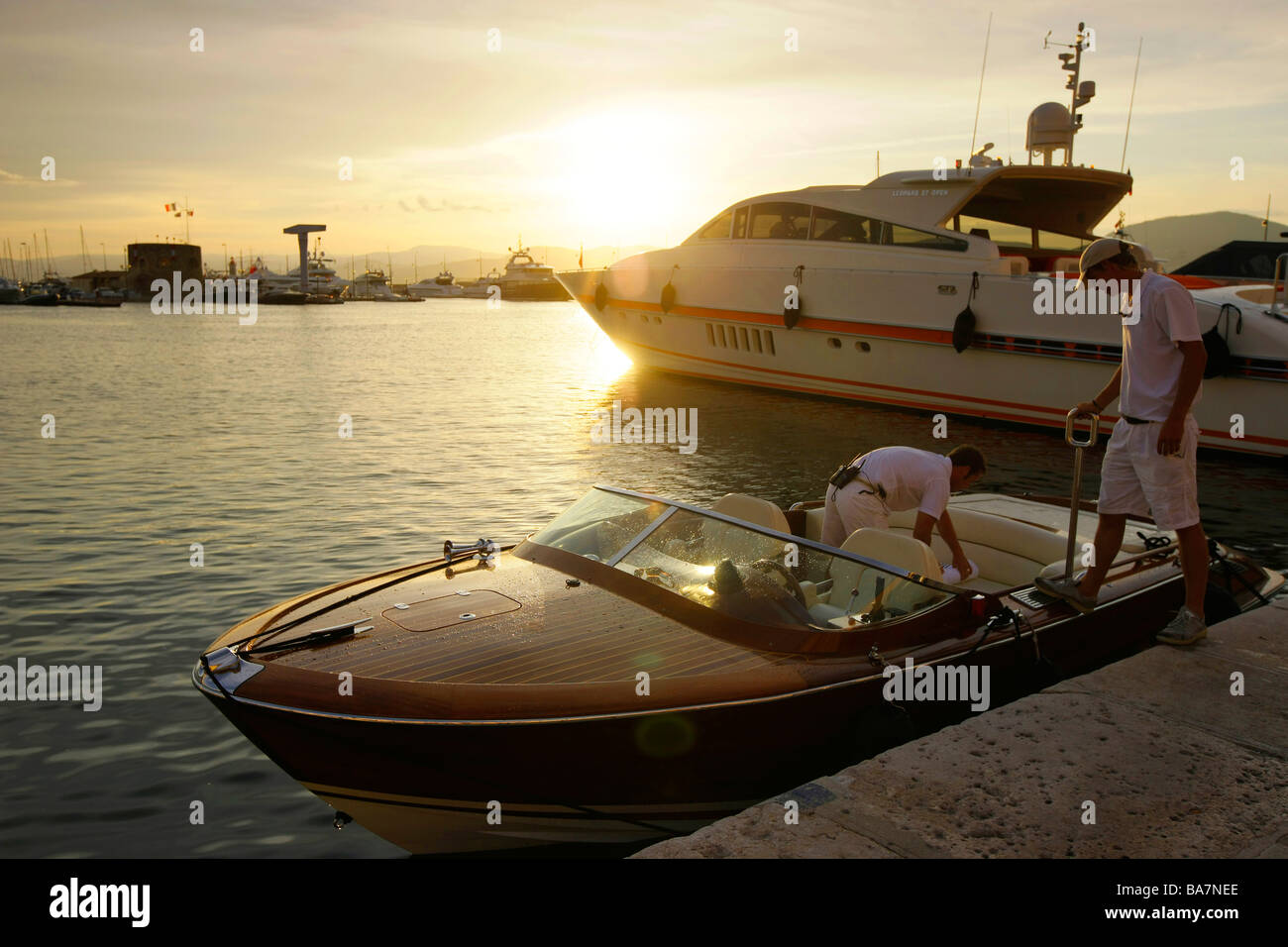 Two men getting into a motor boat at the yacht harbour, yacht ...