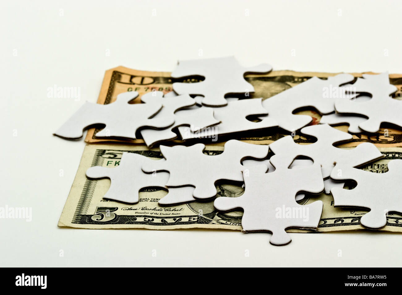 Puzzle pieces on top of an American five and ten dollar bill Stock ...