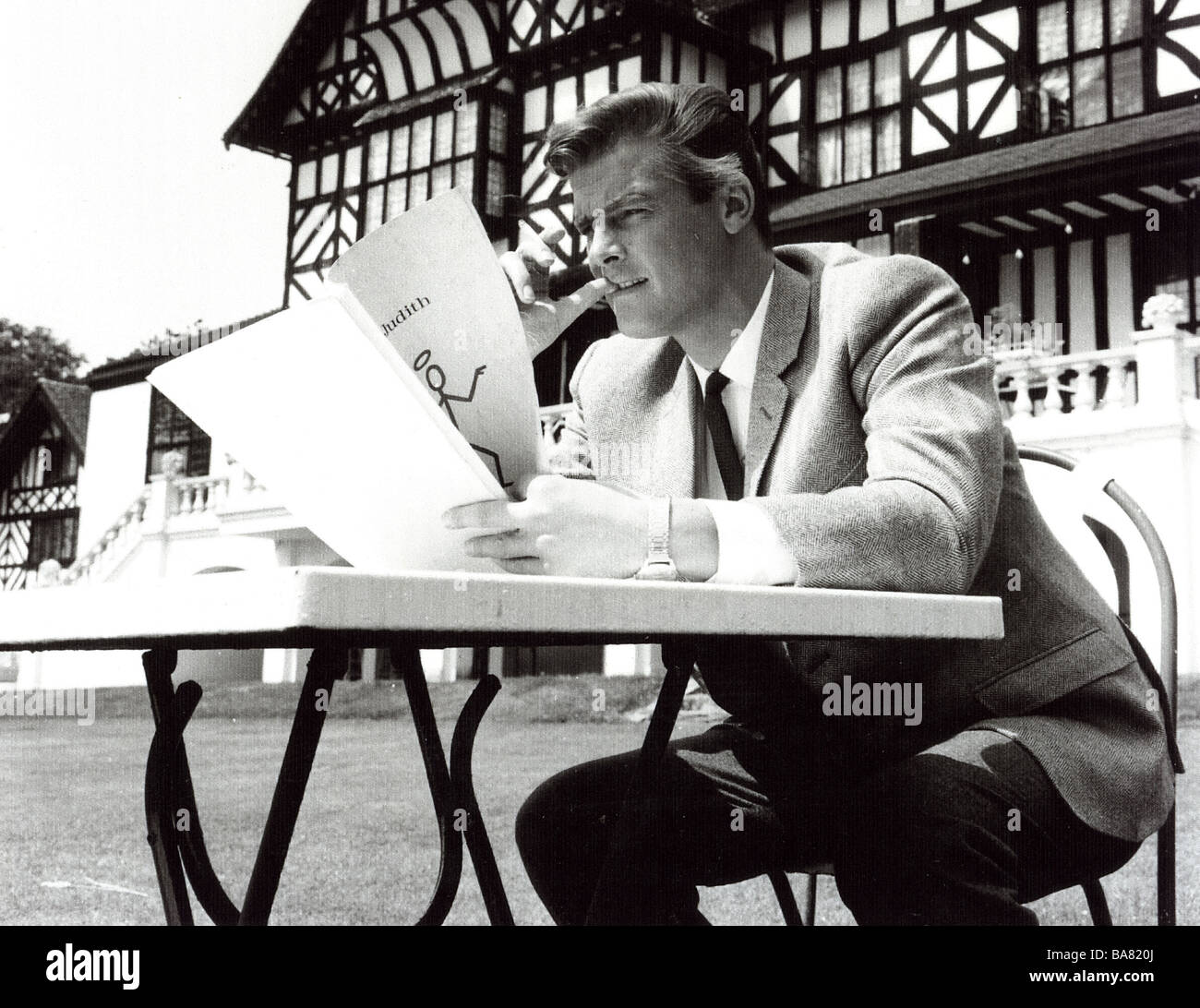 THE SAINT Roger Moore script reading during a break in shooting a 1962 ...