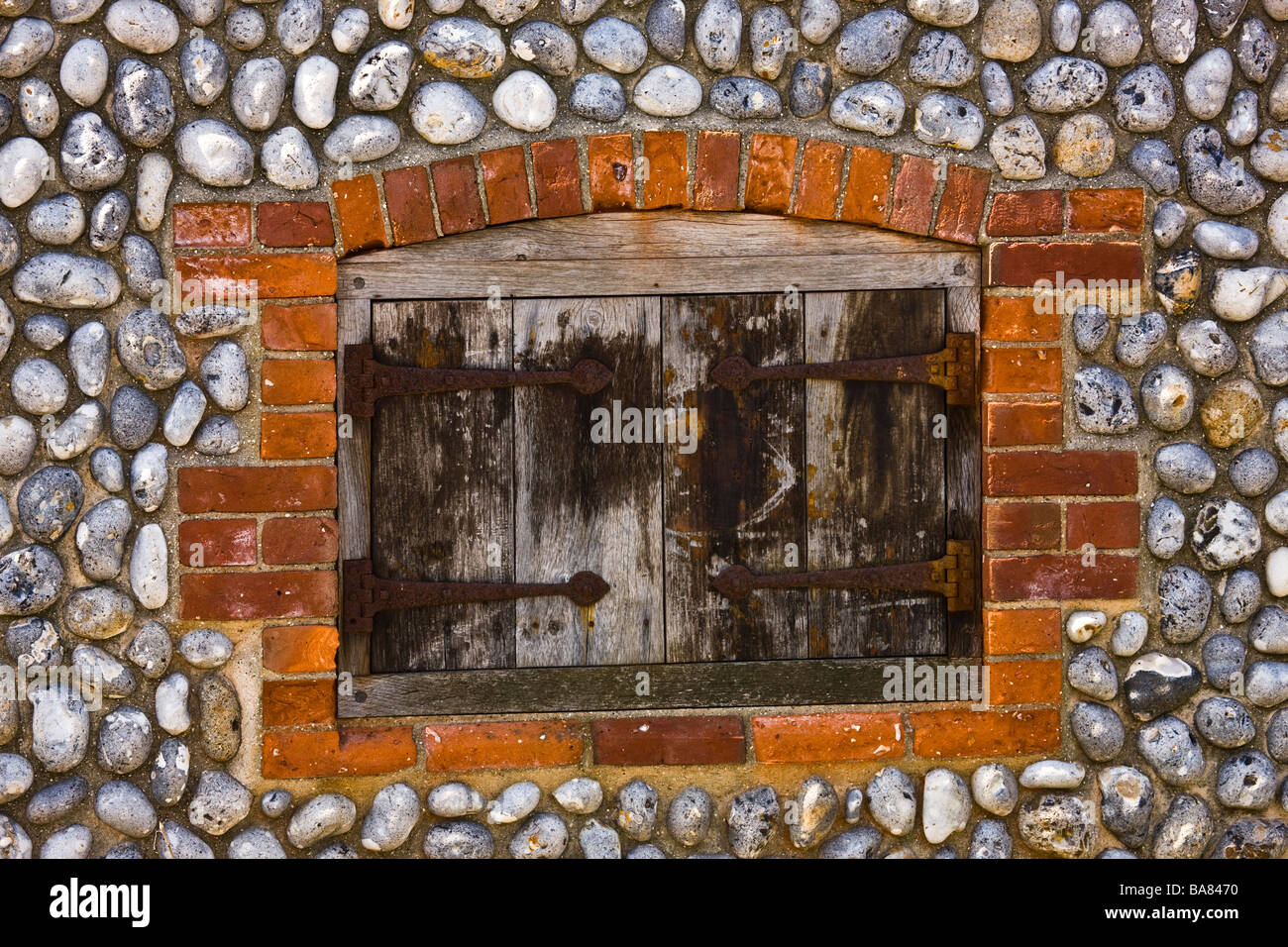 Shuttered window in brick and flint wall Stock Photo - Alamy