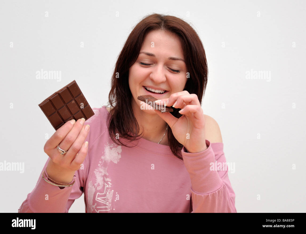 Young woman eating bar of chocolate Stock Photo - Alamy