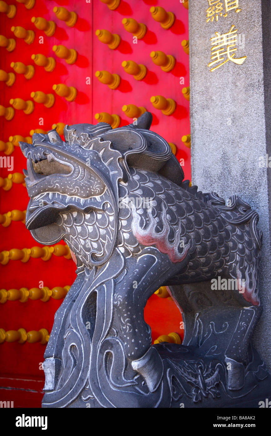 Lion statue by red door Stock Photo - Alamy