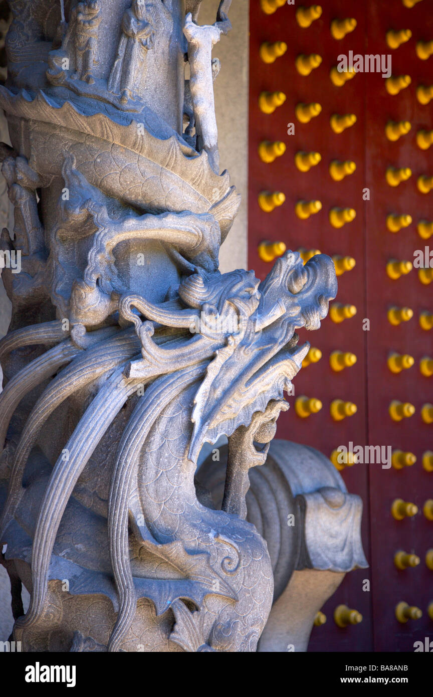 Stone lion statue by red door Stock Photo - Alamy