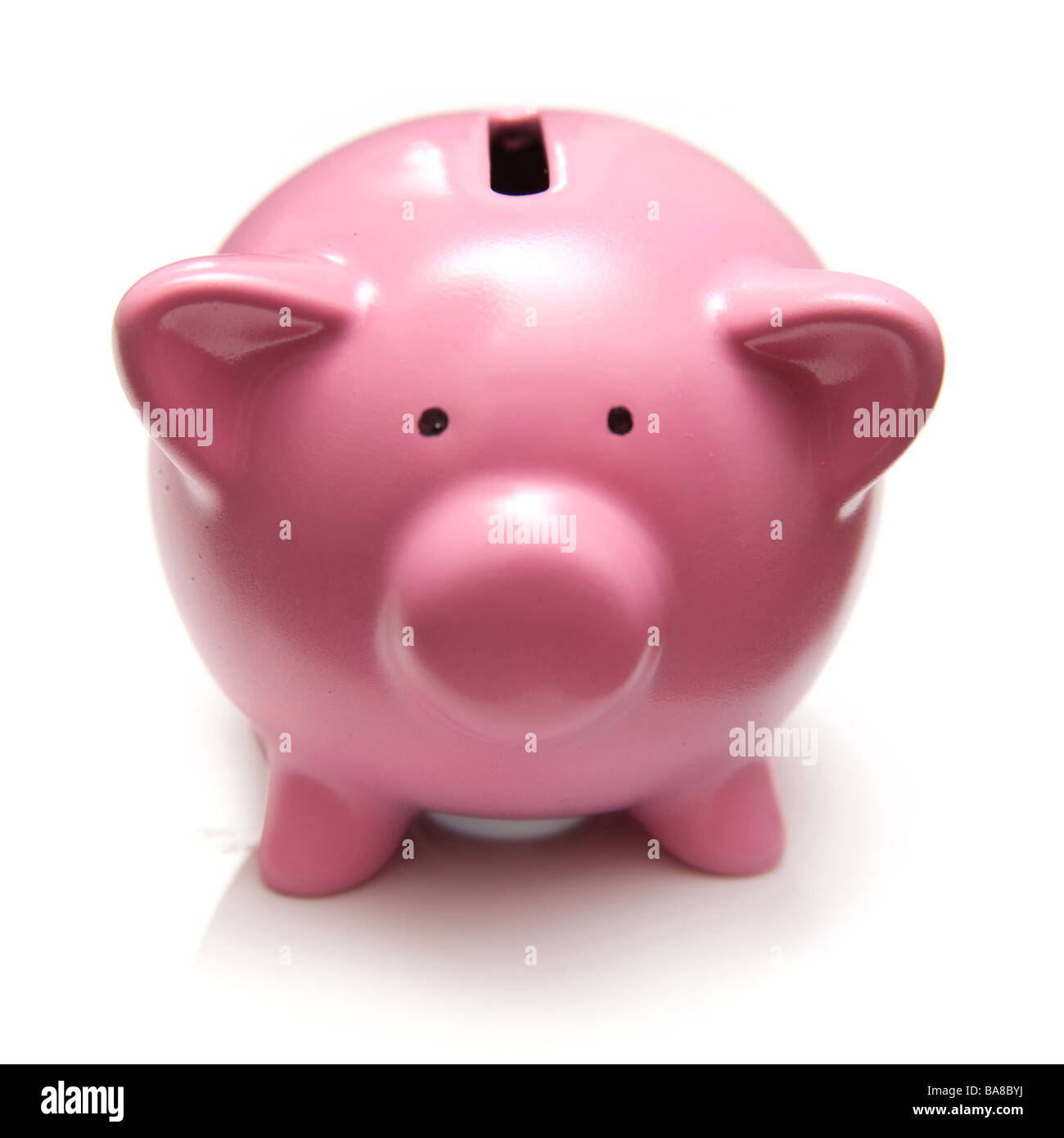 Pink piggy bank style money box isolated on a white studio background ...