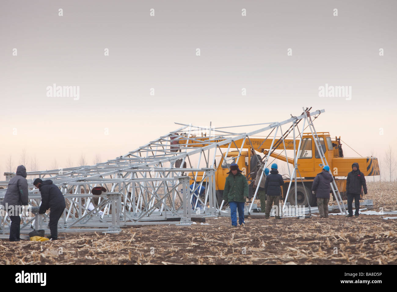 Chinese workers erect a new electricity pylon Stock Photo - Alamy