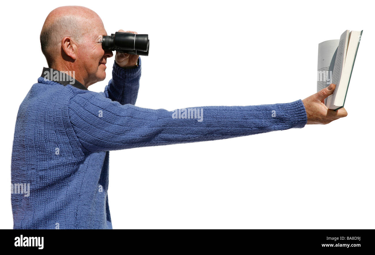 Short sighted man needs binoculars to read his book Stock Photo - Alamy