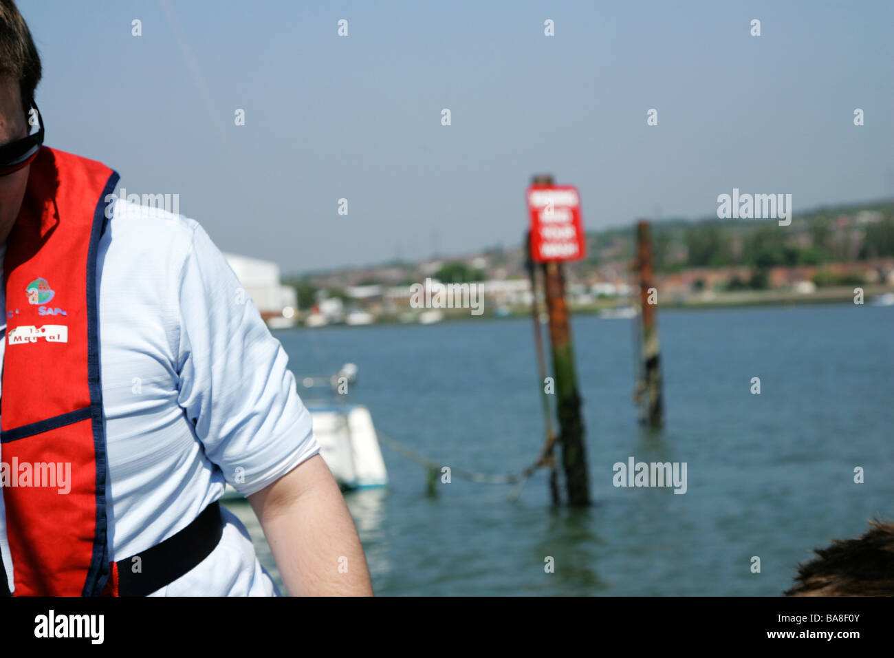 Man stood on boat in harbour with warning signs behind Stock Photo - Alamy