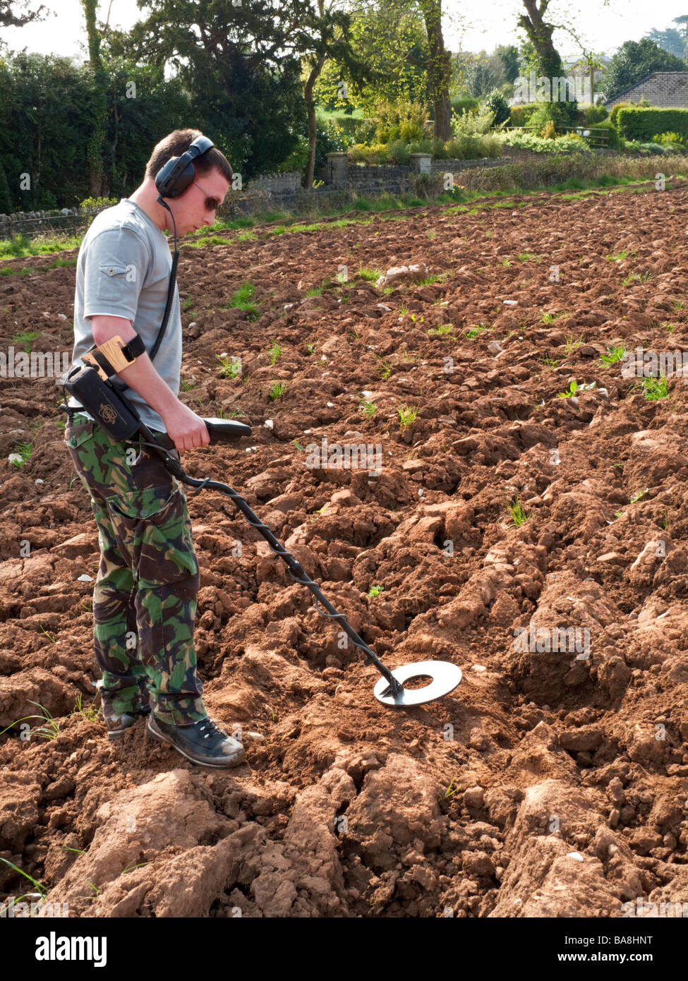 MAN WITH METAL DETECTOR IN PLOUGHED FIELD UK Stock Photo - Alamy