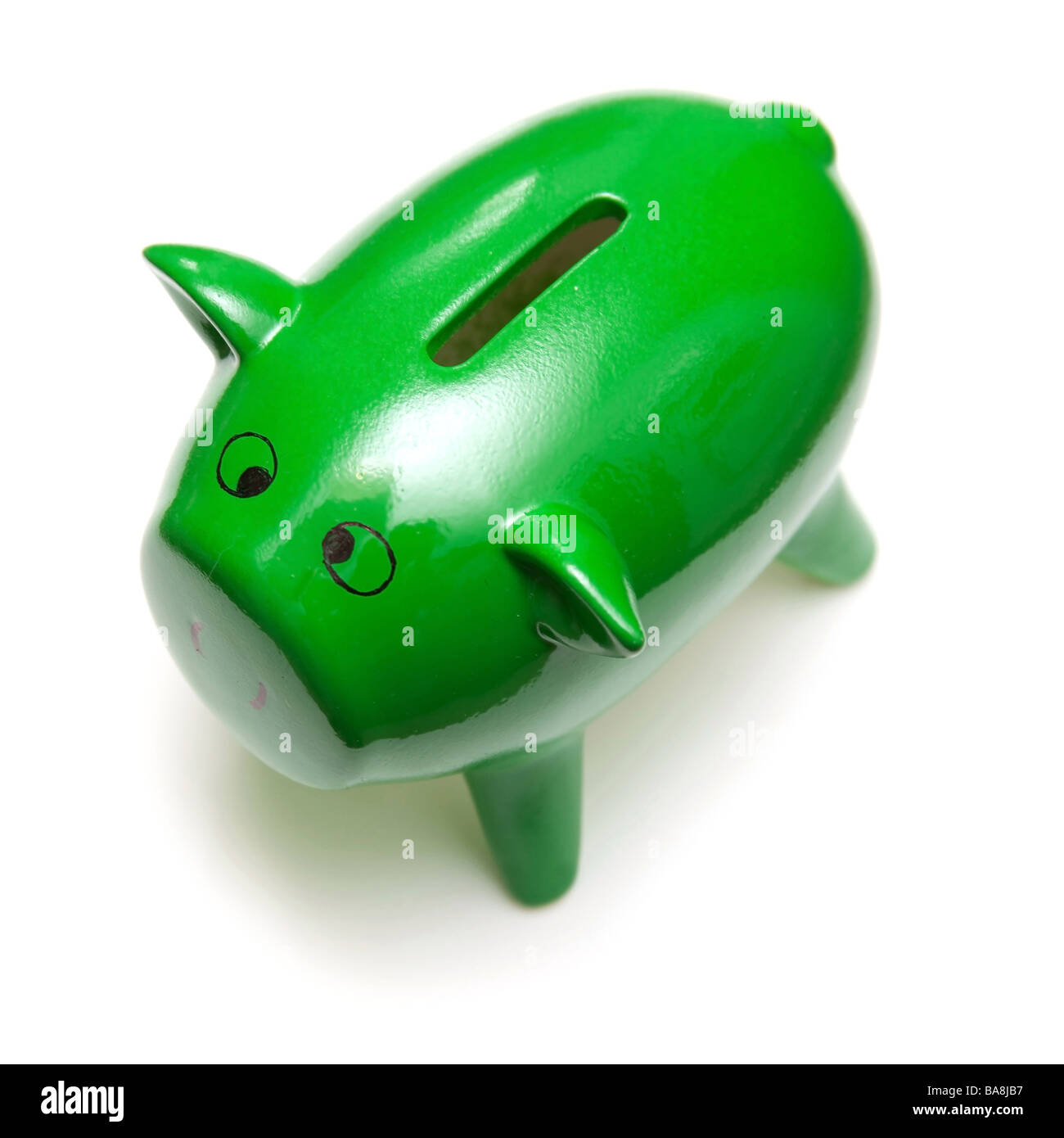 Green piggy bank style money box isolated on a white studio background ...