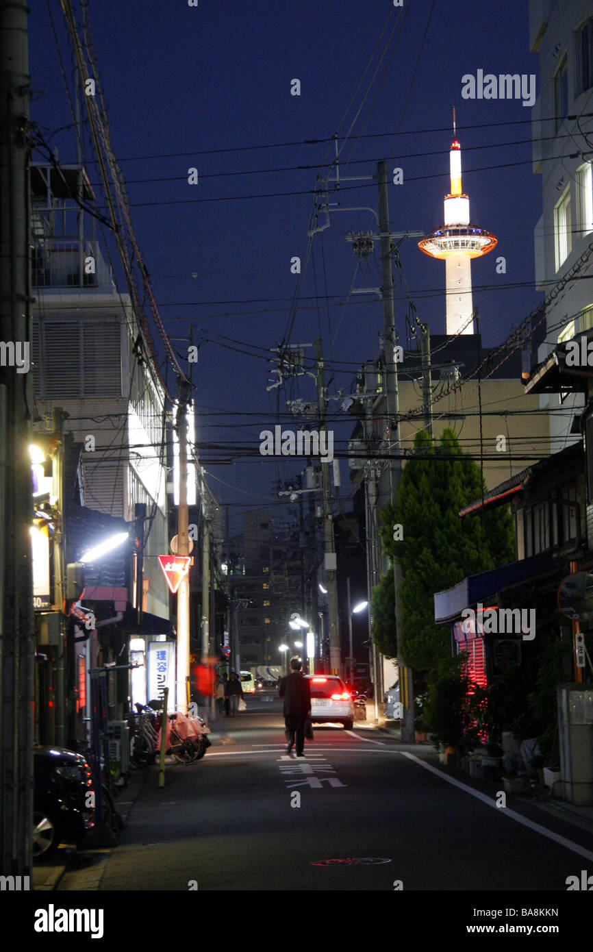 Back street alley in Kyoto at night with the Kyoto Tower raising above ...