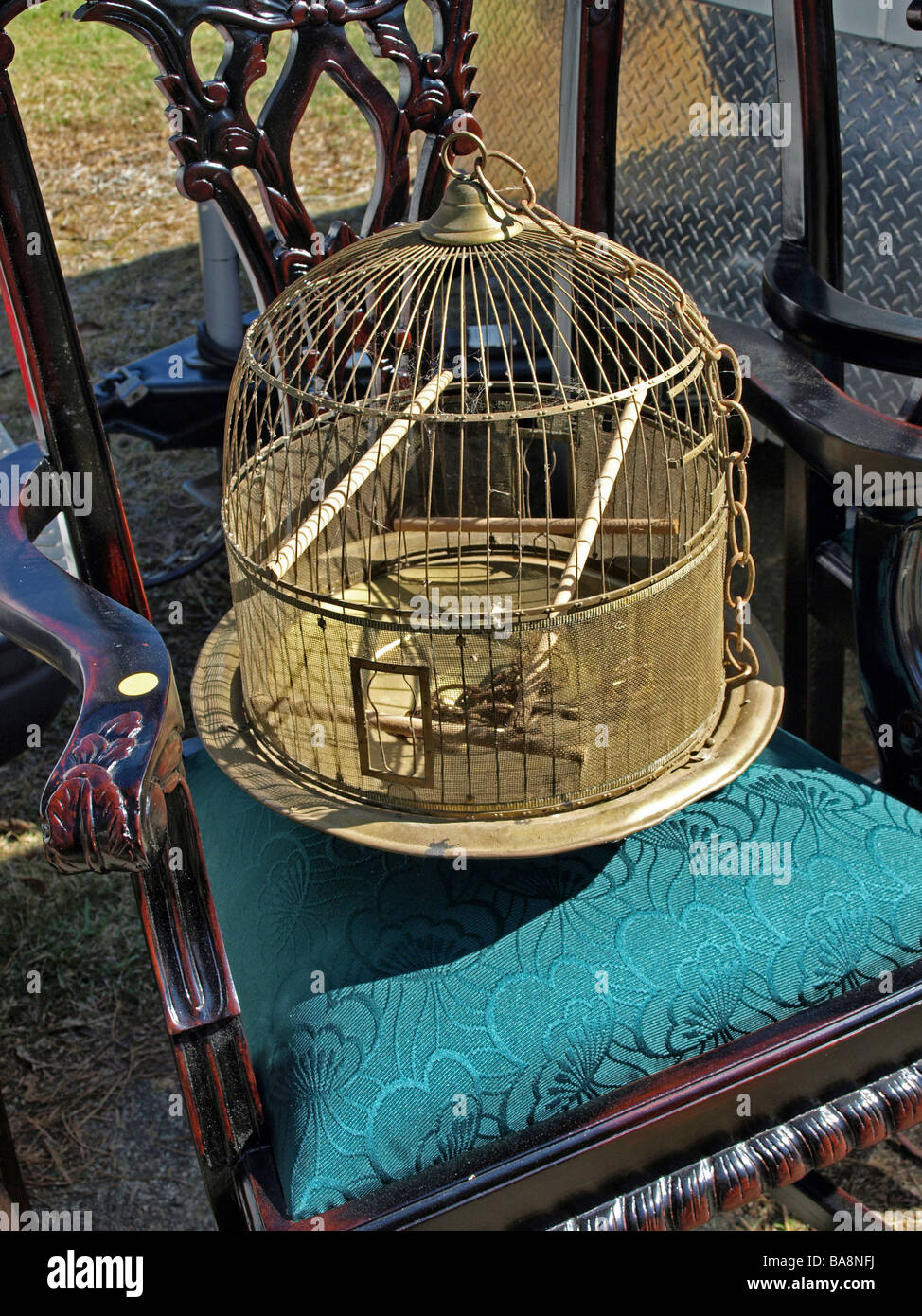 gold golden metal bird cage sitting on a blue green arm chair armchair ...