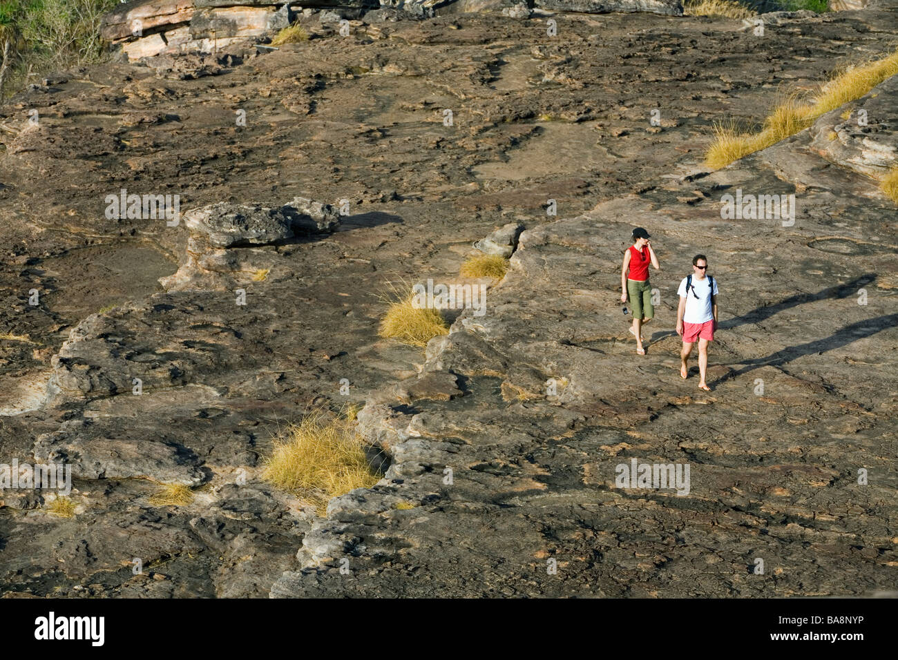 Tourists hike up the escarpment to the Nadab lookout at Ubirr. Kakadu National Park, Northern ...