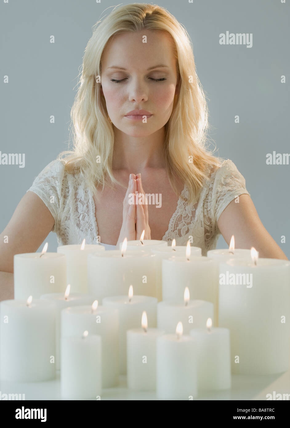 Woman meditating with candles Stock Photo - Alamy