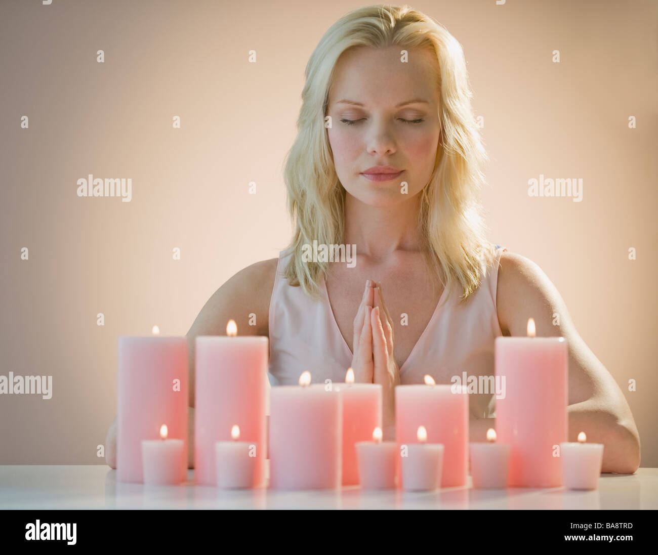 Woman meditating with candles Stock Photo - Alamy