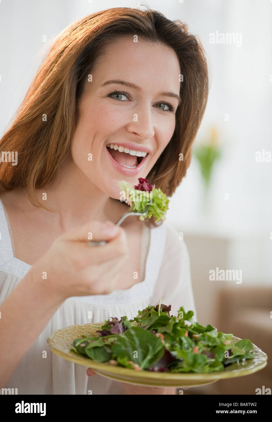 Woman eating salad Stock Photo - Alamy