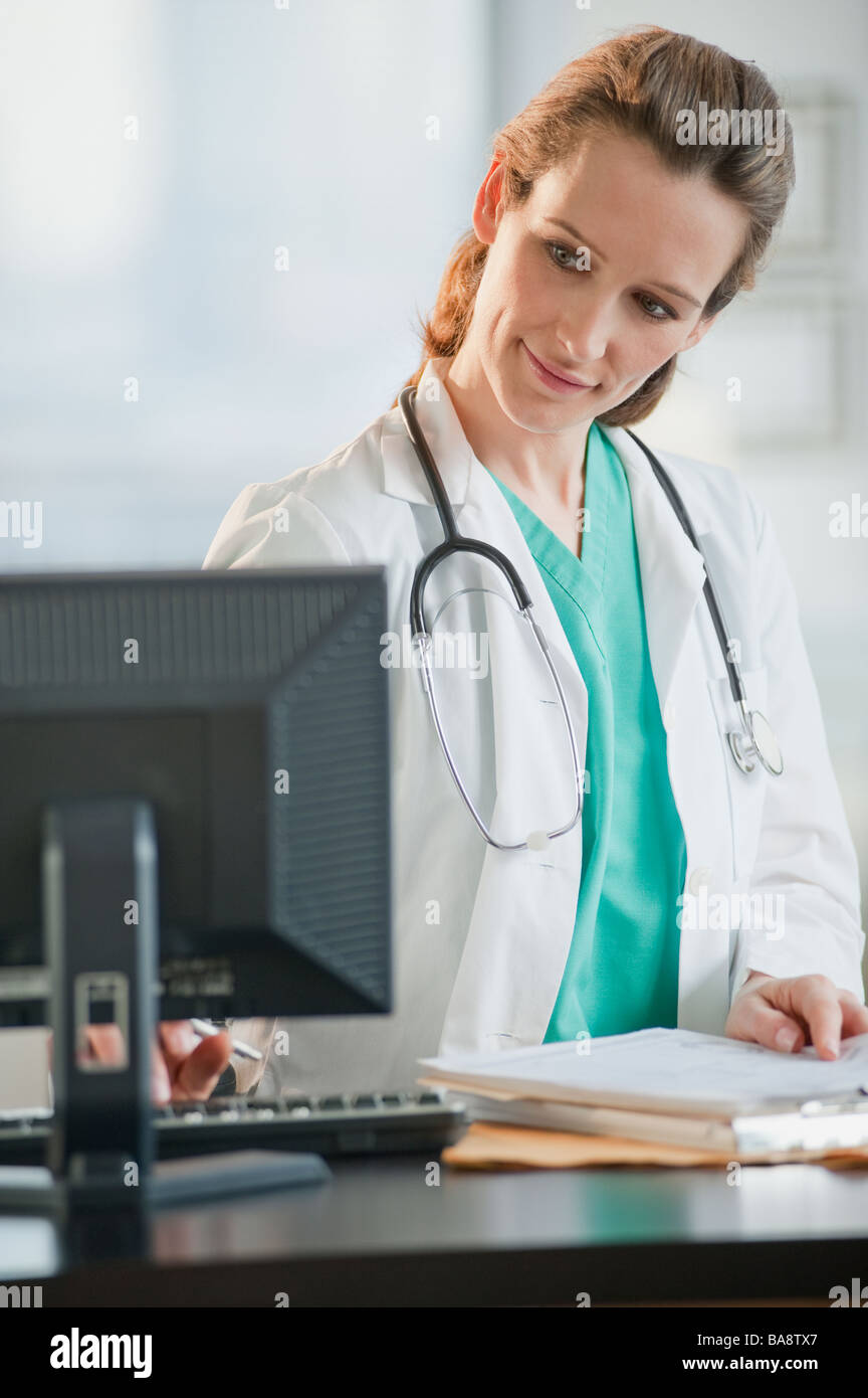 Female doctor looking at computer monitor Stock Photo - Alamy
