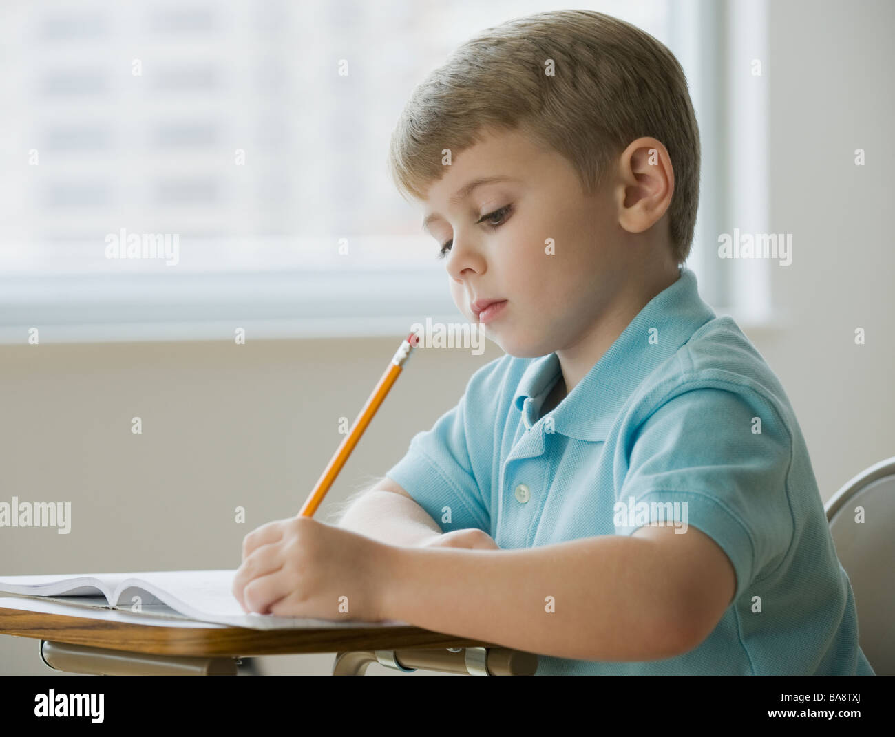 Boy writing in classroom Stock Photo - Alamy