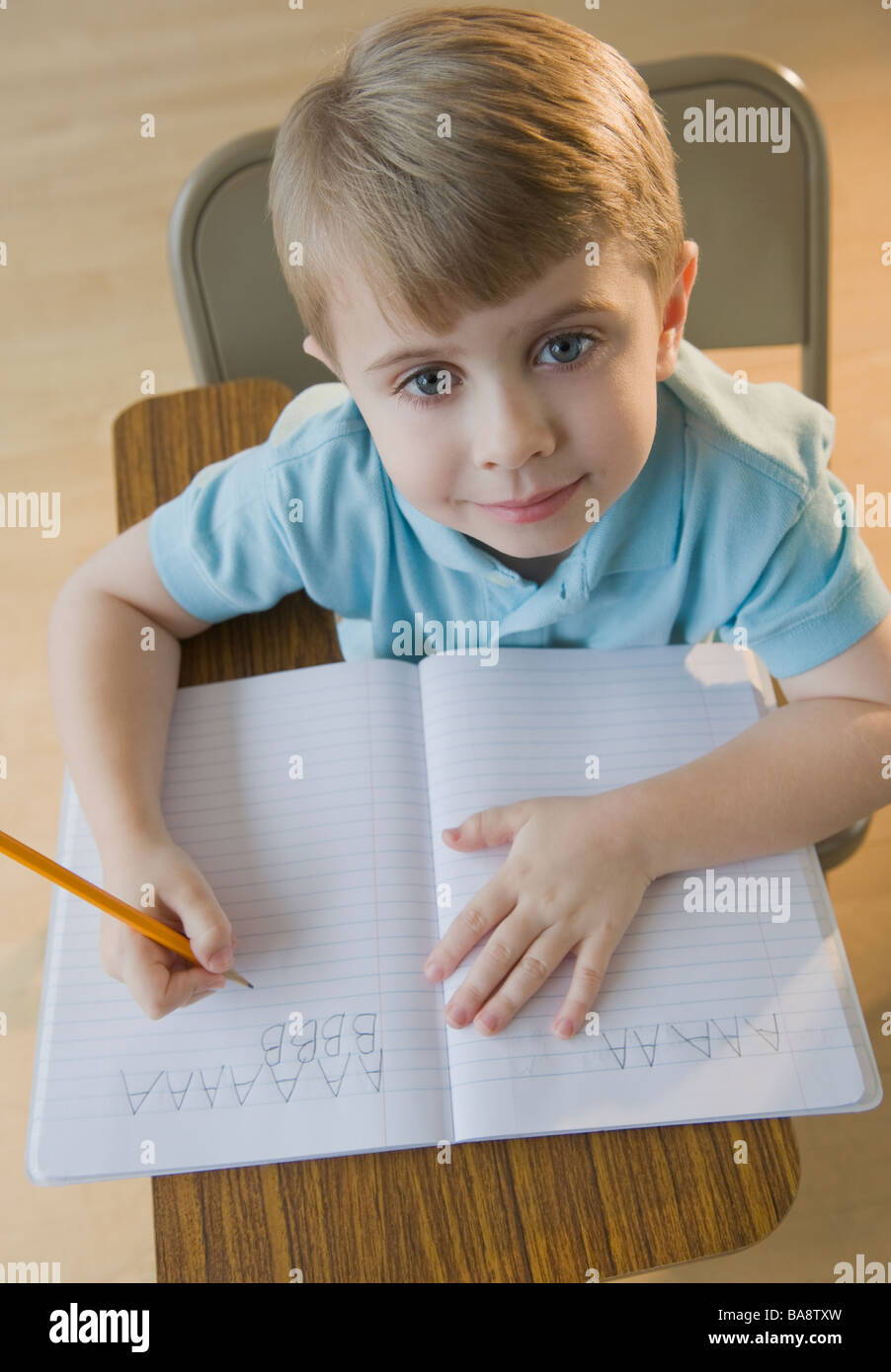 Boy writing letters in classroom Stock Photo - Alamy
