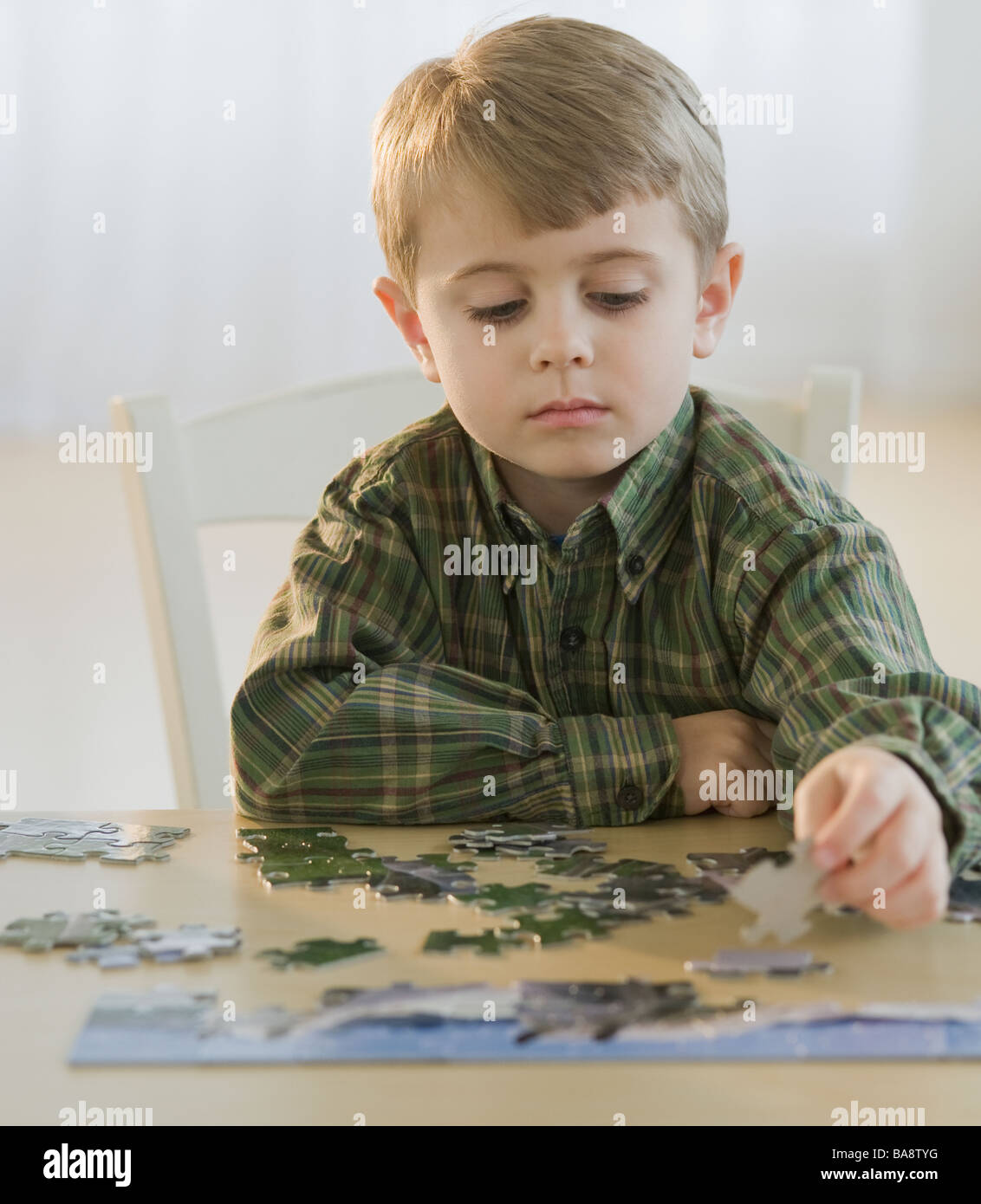 Boy assembling puzzle Stock Photo - Alamy
