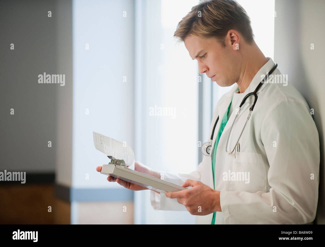 Doctor reading medical chart Stock Photo - Alamy