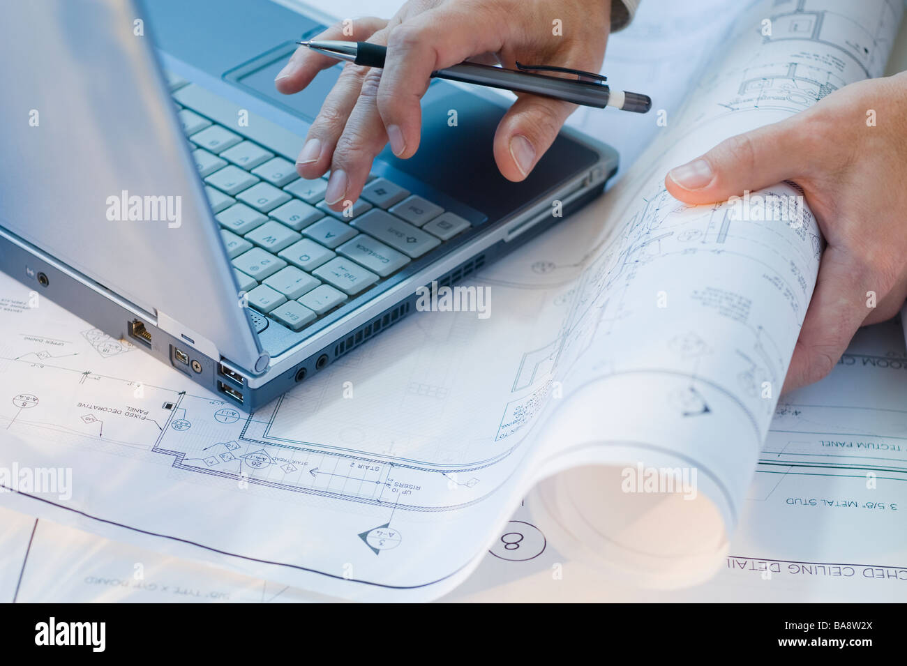 Architect with blueprints and laptop Stock Photo - Alamy