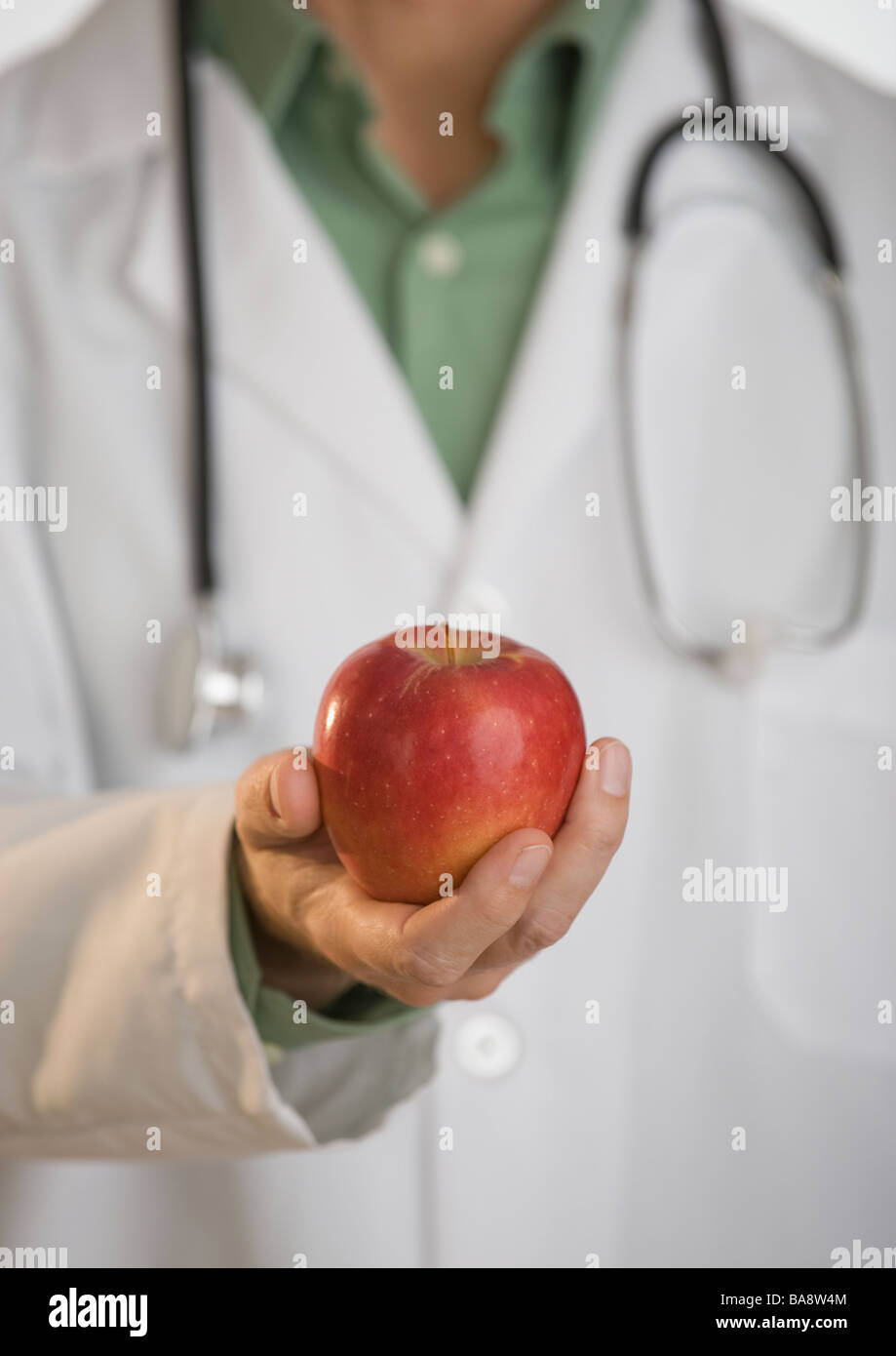Doctor holding apple Stock Photo - Alamy