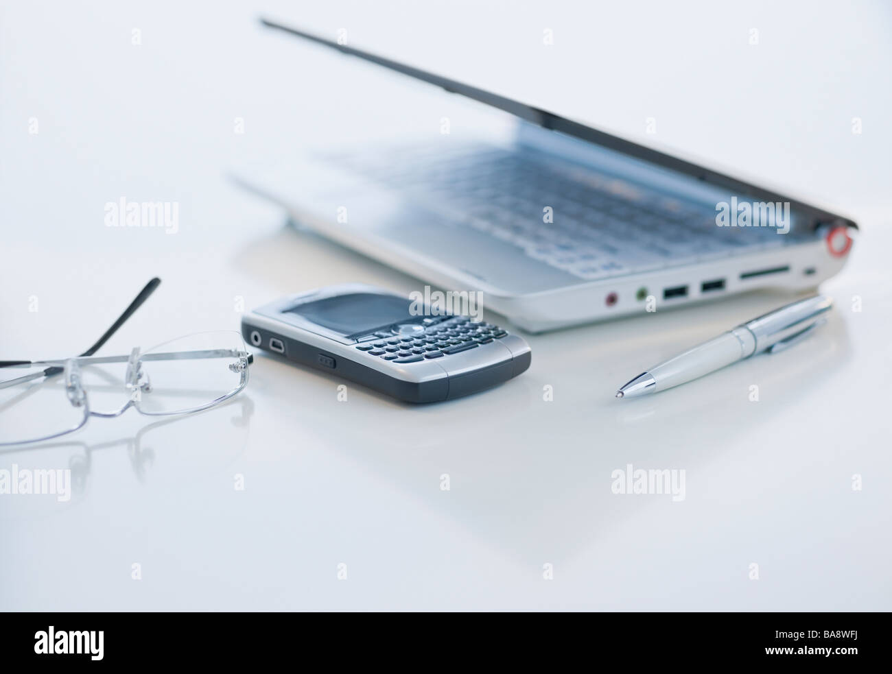 Cell phone and laptop on desk Stock Photo - Alamy