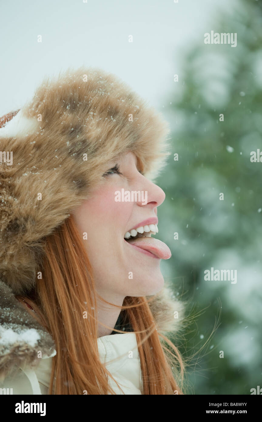 Woman catching snow on tongue Stock Photo - Alamy