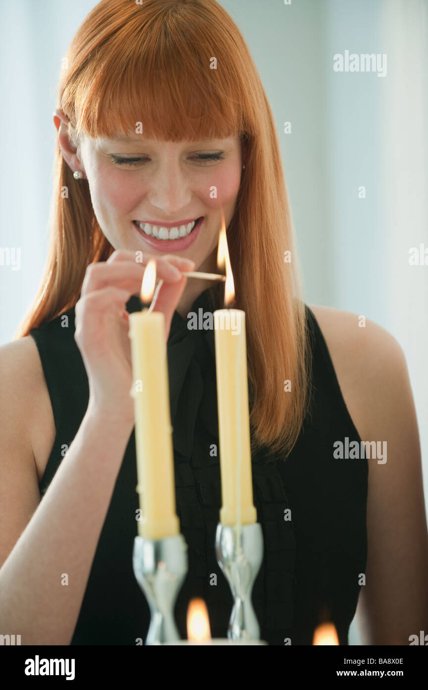 Woman lighting holiday candles Stock Photo - Alamy
