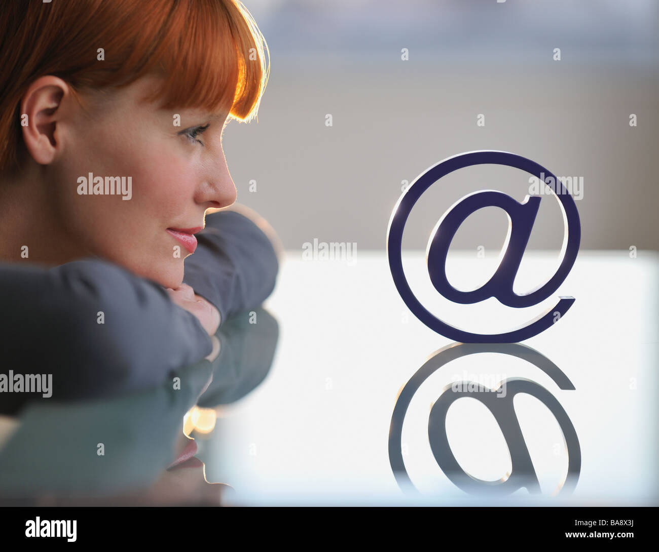 Woman looking at “at” symbol Stock Photo - Alamy