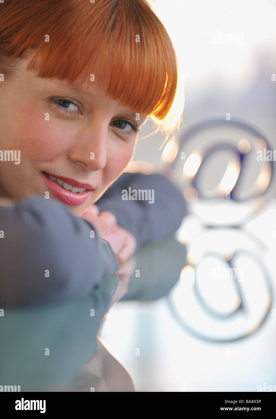 Woman looking at “at” symbol Stock Photo - Alamy