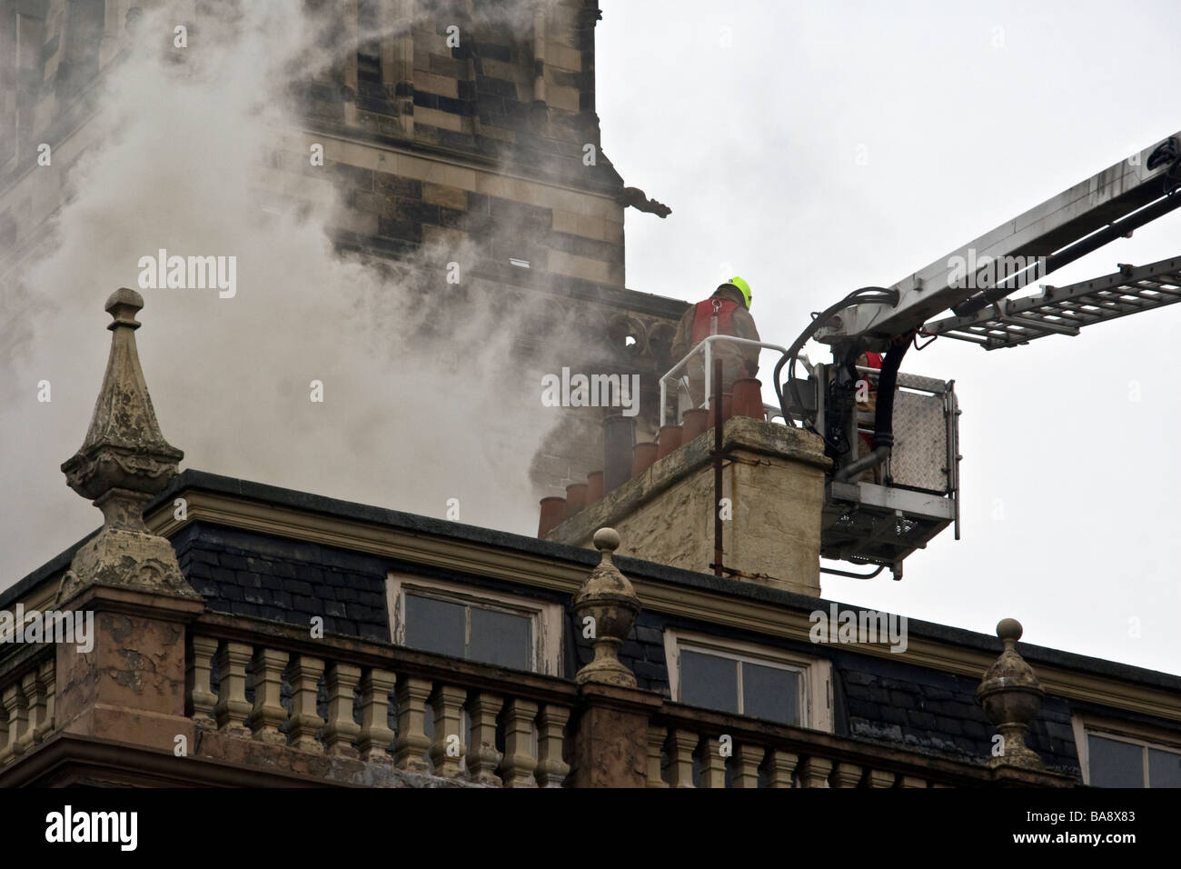 Firemen extinguishing smoke billowing out from the rooftops of local ...
