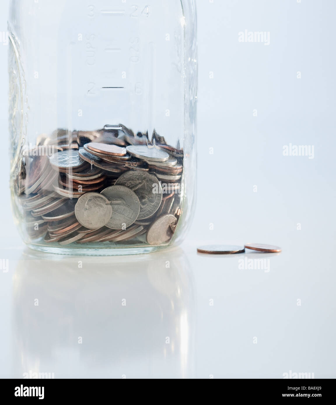 Coins in savings jar Stock Photo - Alamy