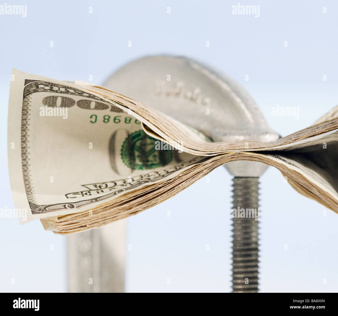 Paper currency squeezed in C clamp Stock Photo - Alamy
