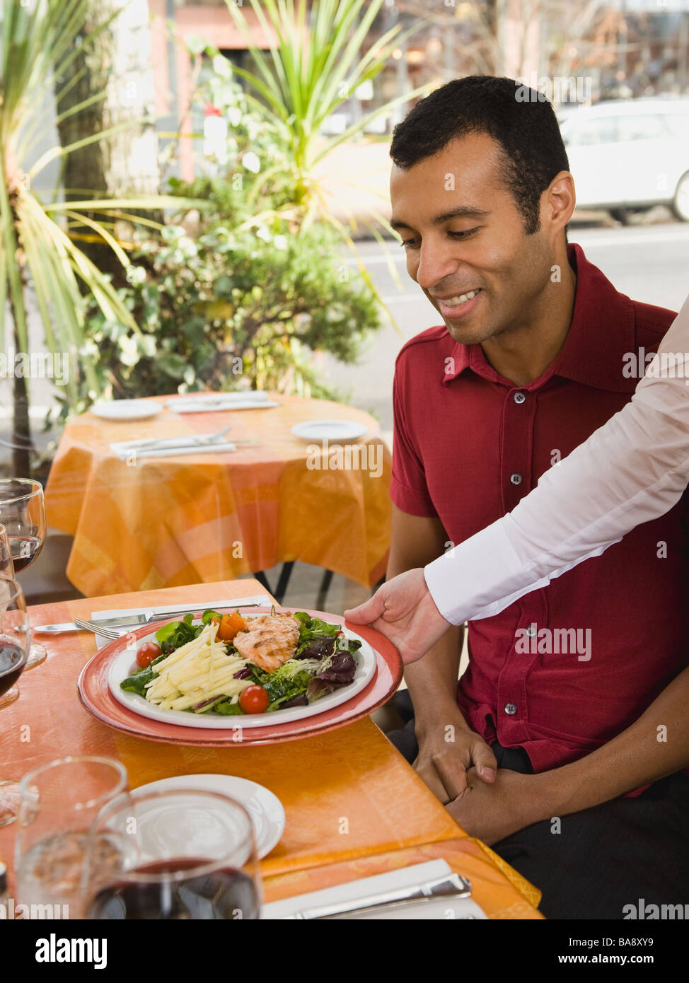 Waiter serving food to man in restaurant Stock Photo - Alamy